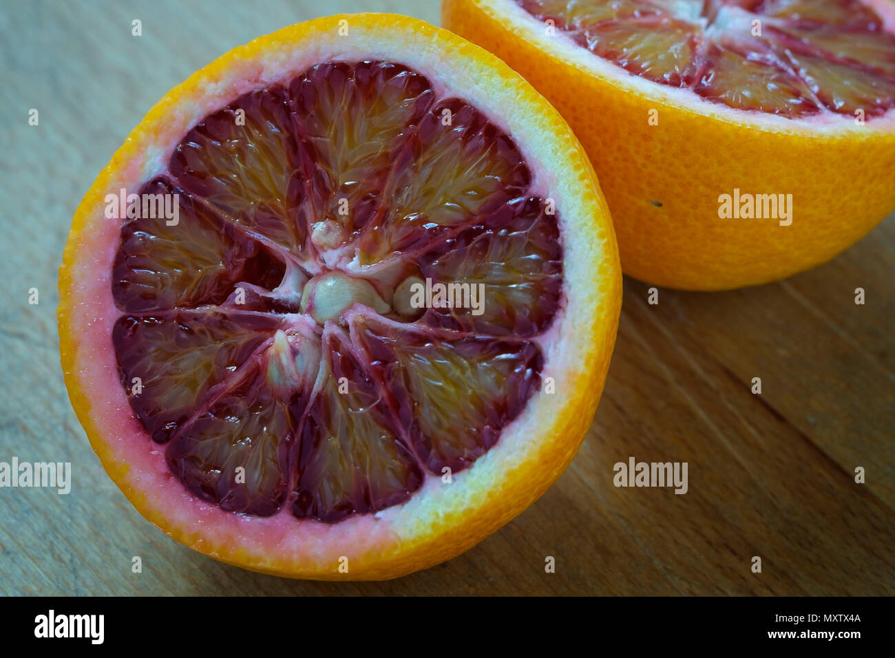Organic blood orange freshly cut in half Stock Photo - Alamy