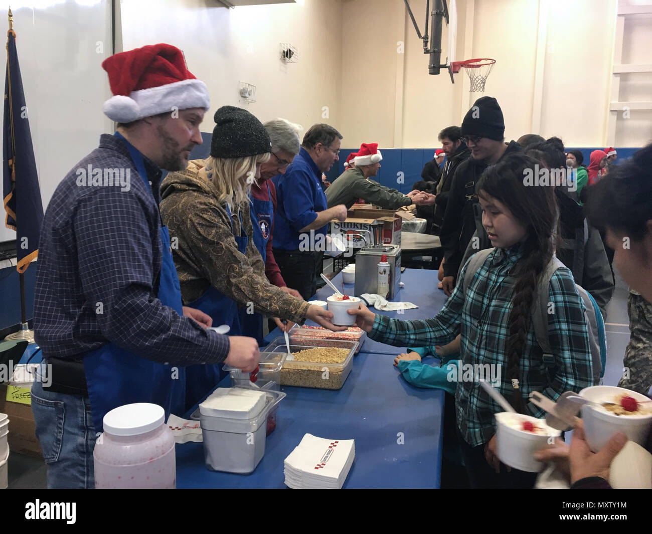 Volunteers for Operation Santa Claus make sundaes for children in ...