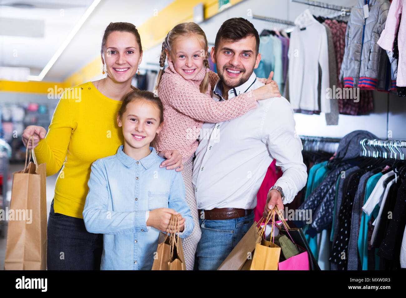 Young positive family with two daughters after shopping in store Stock ...