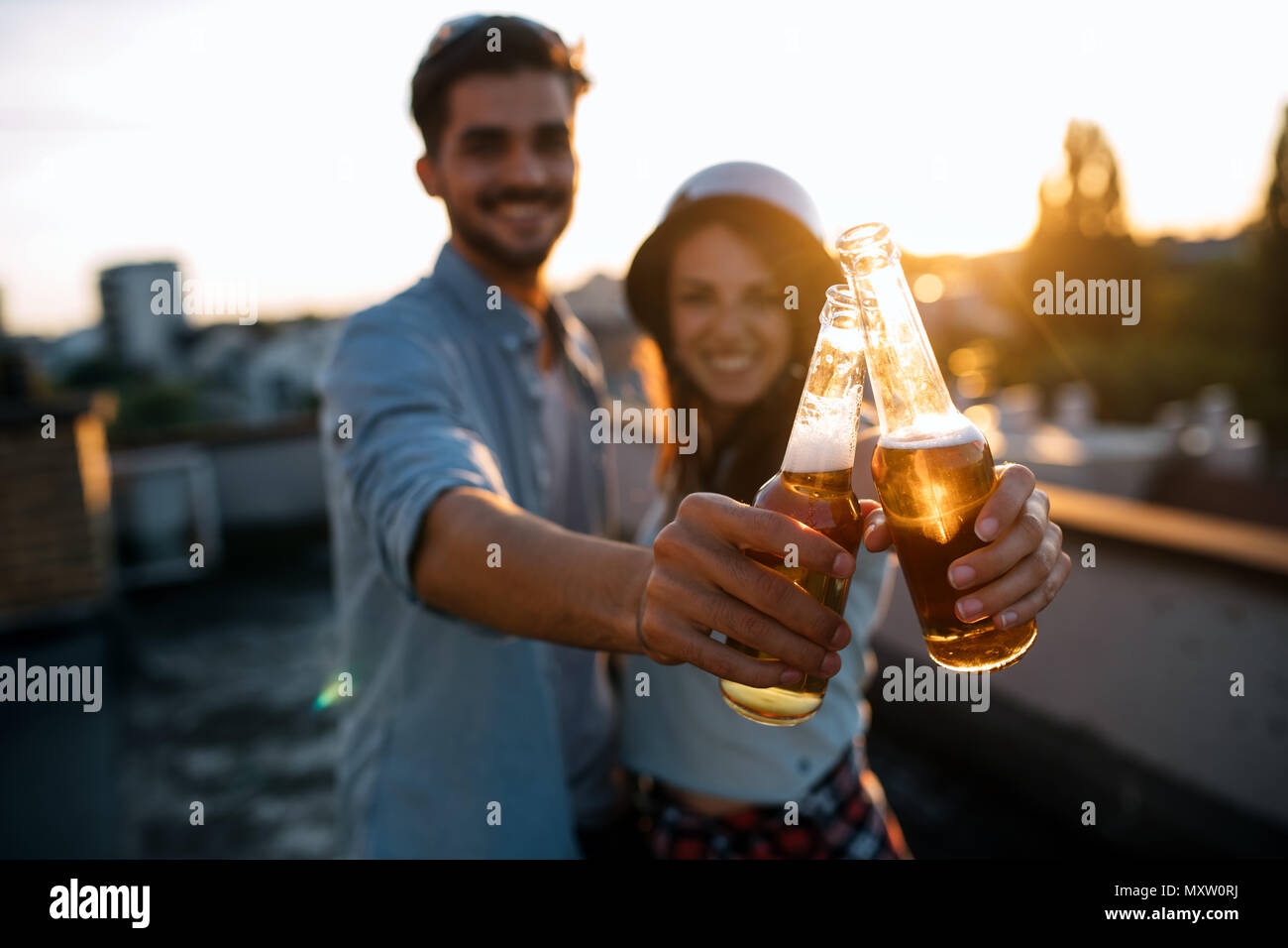 Young happy couple toasting with beer outdoors Stock Photo - Alamy