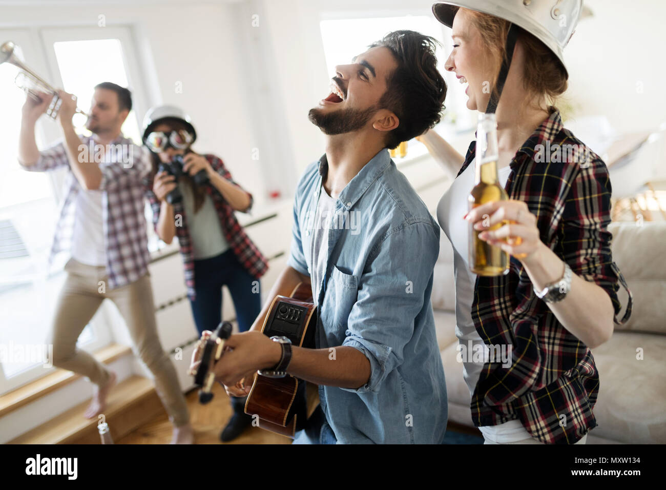 Cheerful friends having party together and playing instruments Stock ...