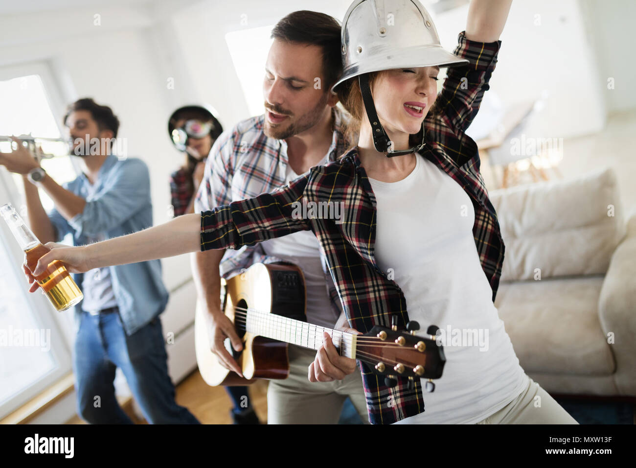 Cheerful friends having party together and playing instruments Stock ...