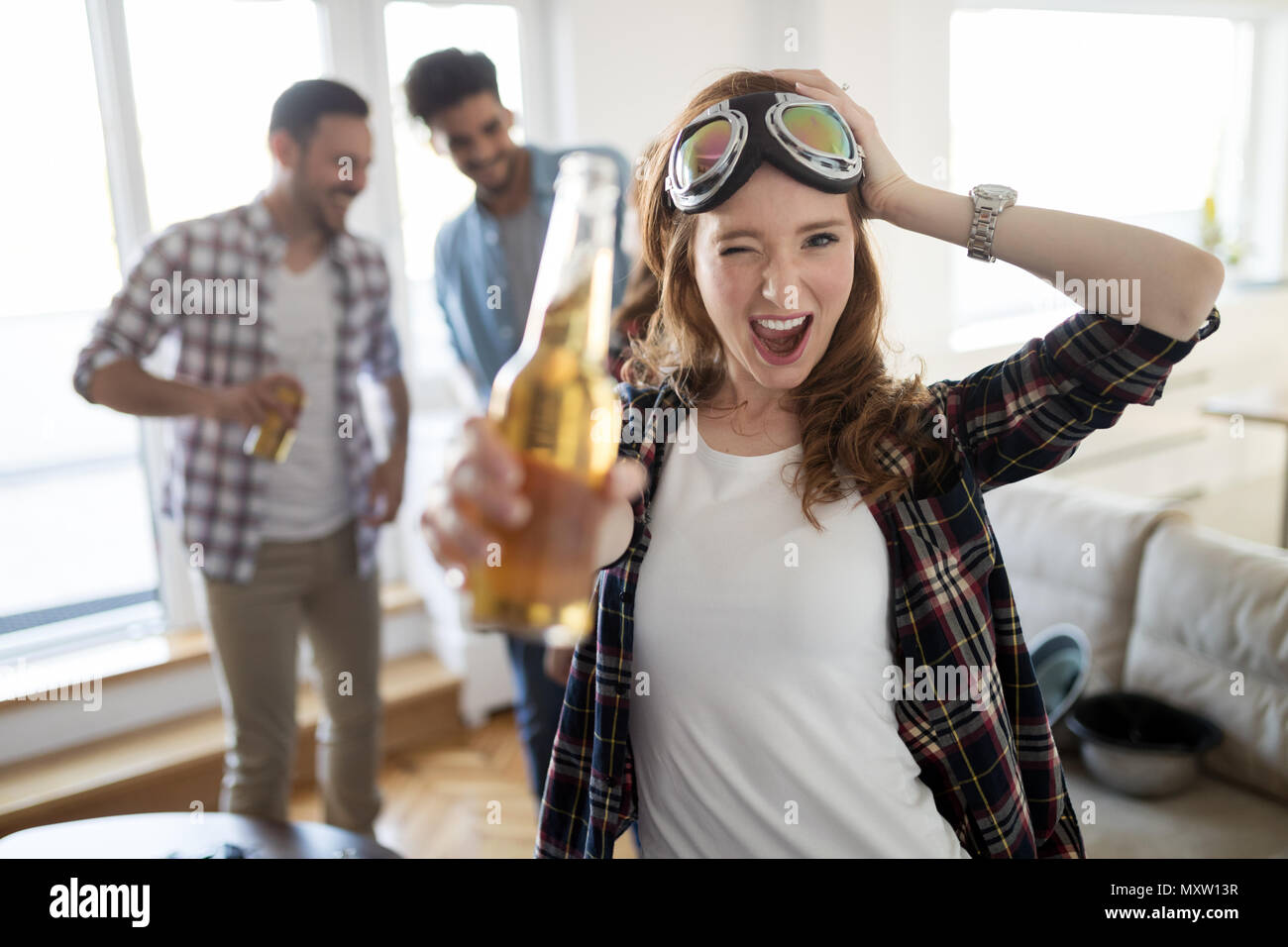 Small group of young people hang out at the house party, friends having ...