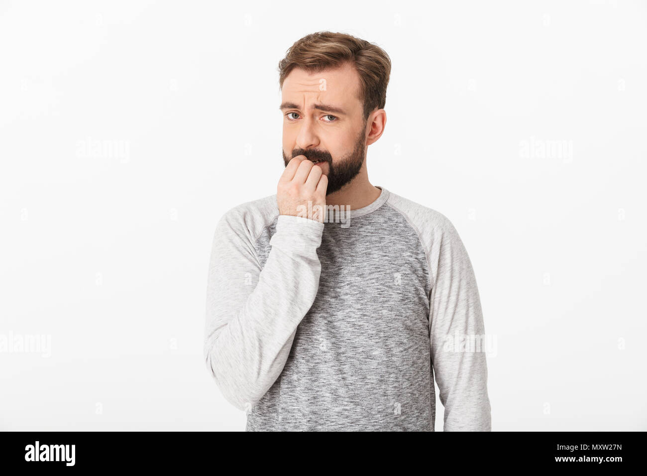 Photo of confused young man isolated over white wall background ...
