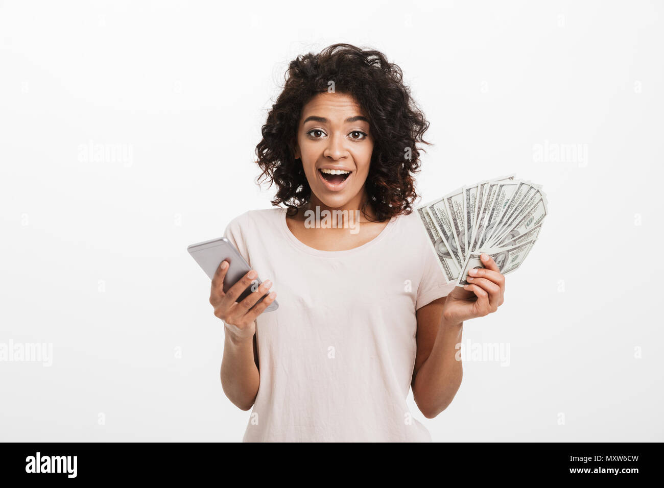Happy winner american woman with afro hairstyle and big smile holding ...