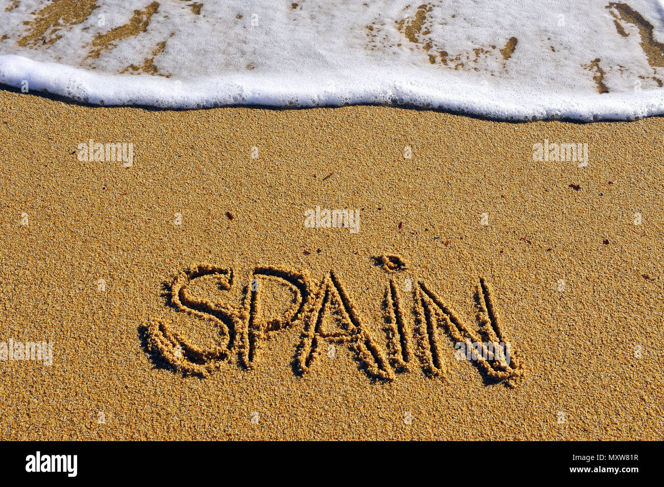 Spain sign on the sand beach, travel background Stock Photo - Alamy