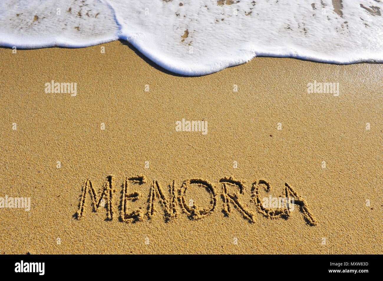 Menorca sign on the golden sand beach background Stock Photo - Alamy