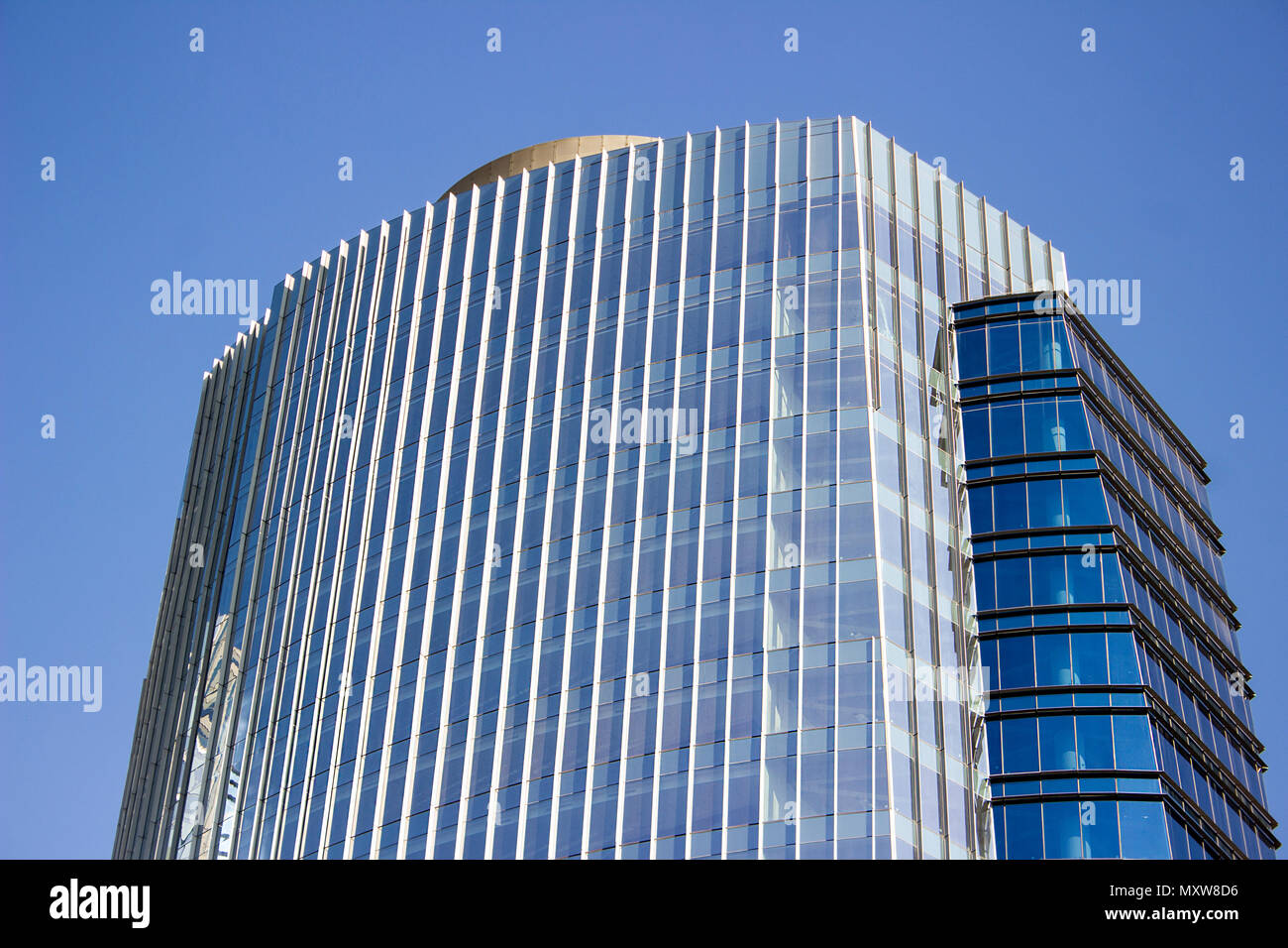 Side view of a blue modern corporate high-rise building with a striped ...