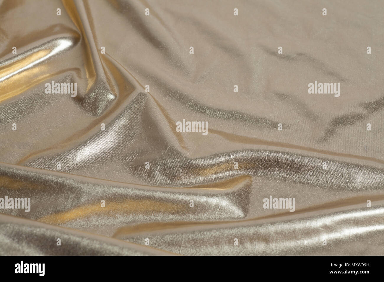 Golden brocade fabric waves background close up Stock Photo - Alamy