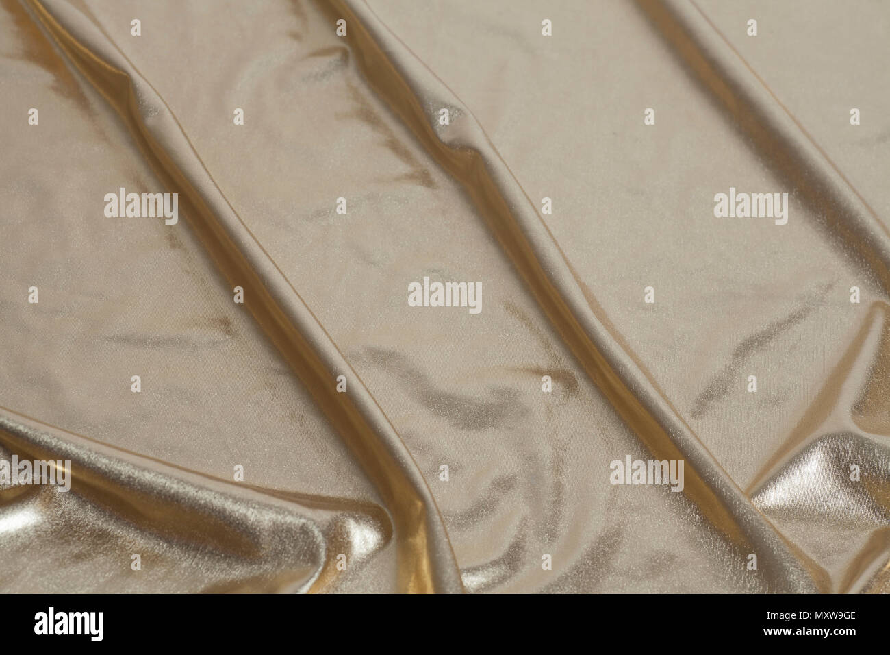 Golden brocade fabric waves background close up Stock Photo - Alamy