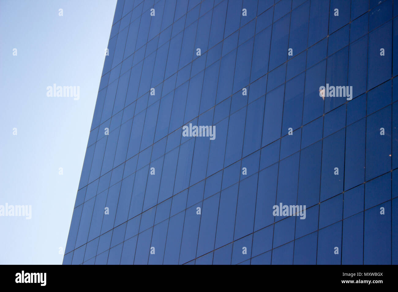 Side view of a smooth blue glass window wall of an office building ...