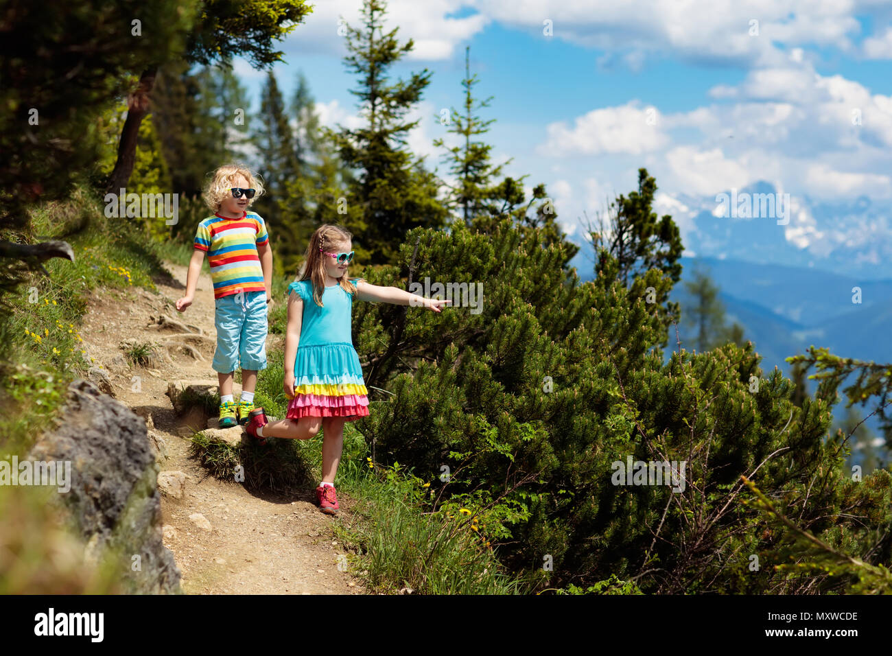 Children hiking in Alps mountains. Kids look at snow covered mountain ...