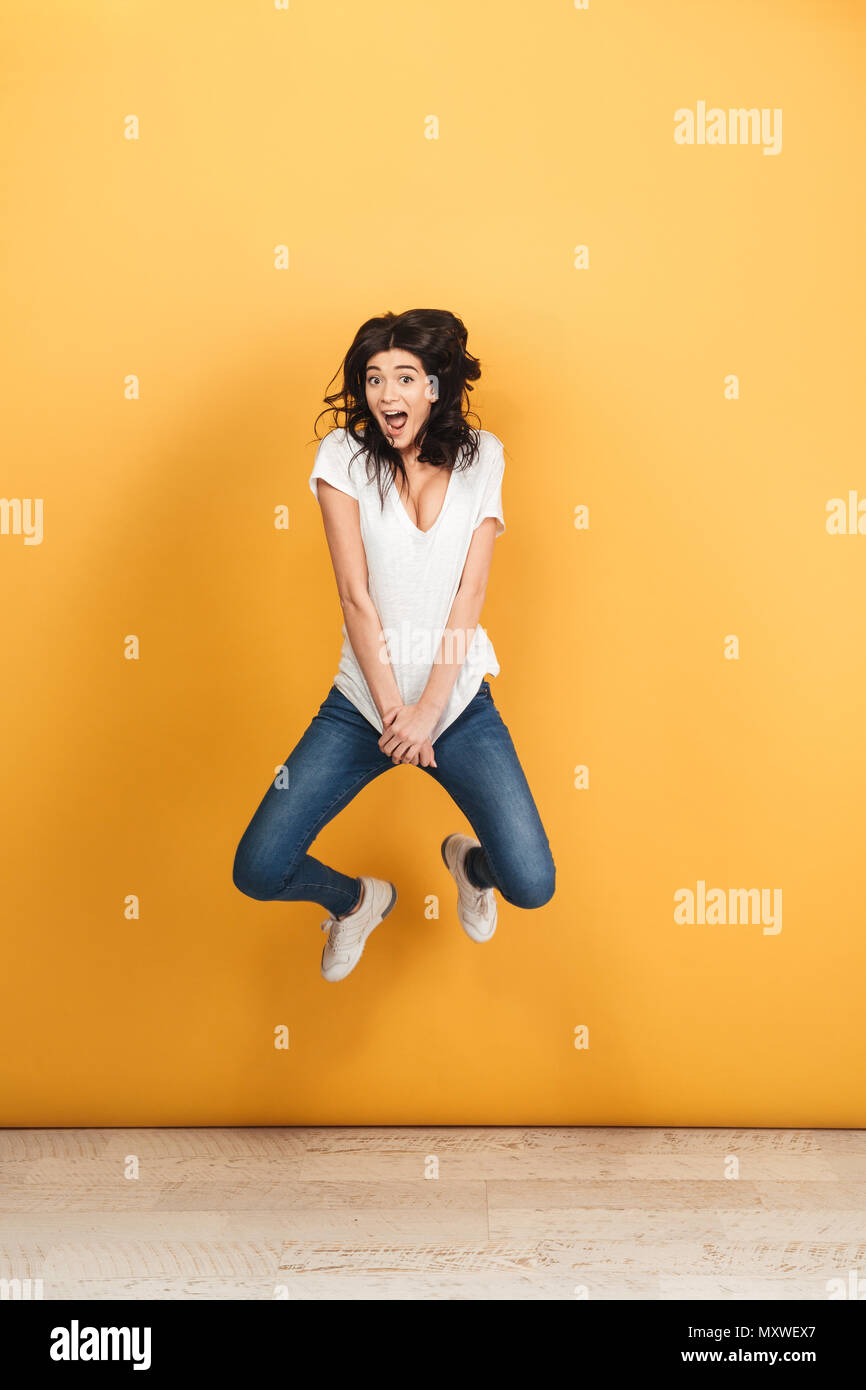 Image of young shocked woman jumping isolated over yellow background ...
