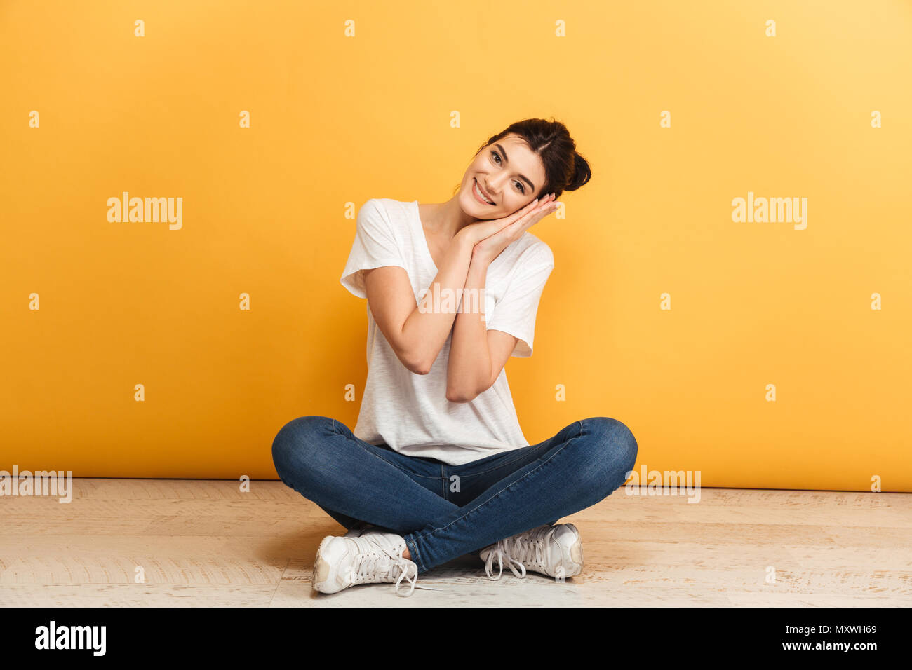 Portrait of a smiling young woman showing sleeping gesture while ...