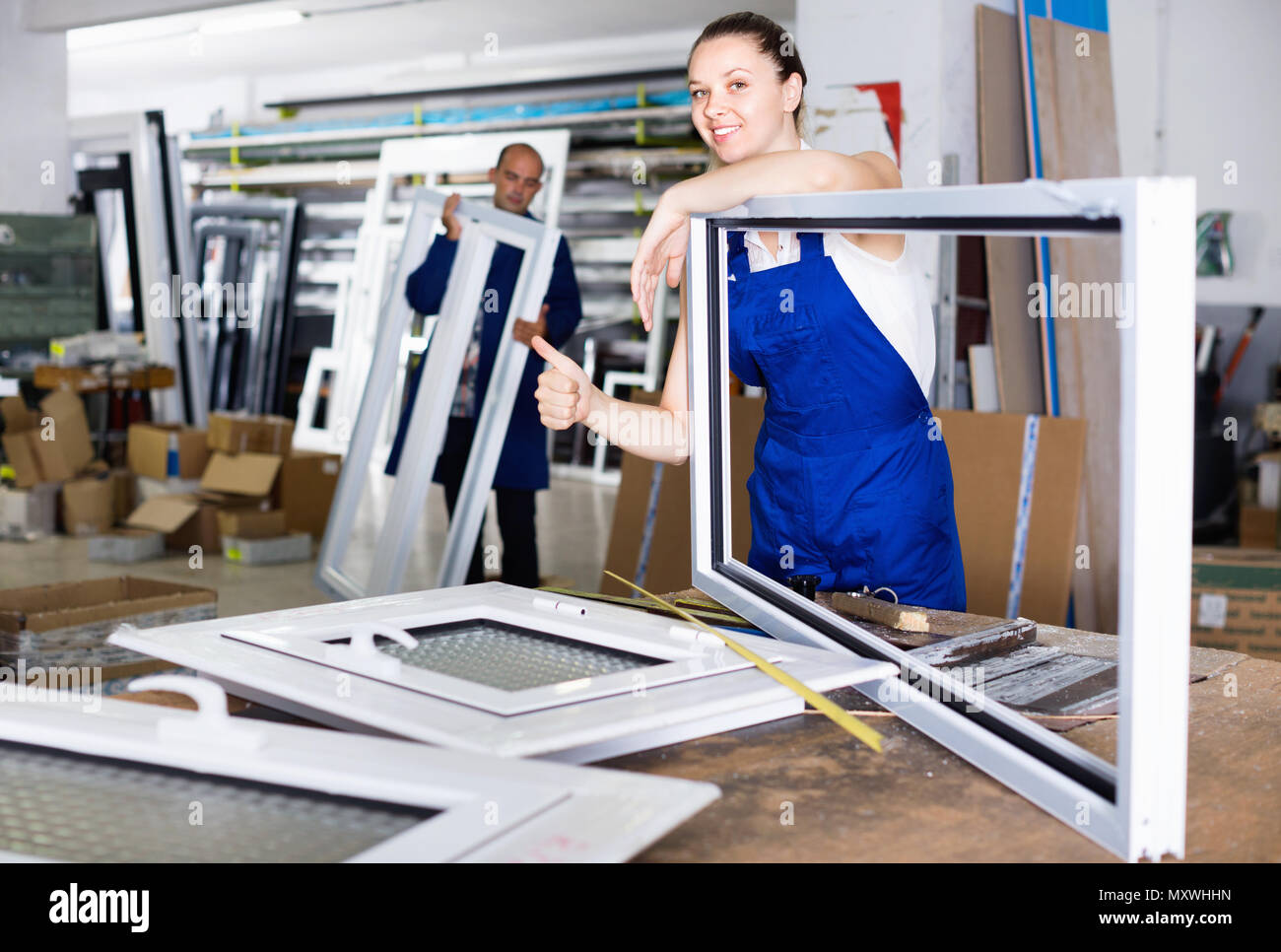 Smiling cheerful positive workwoman with plastic window frame in ...