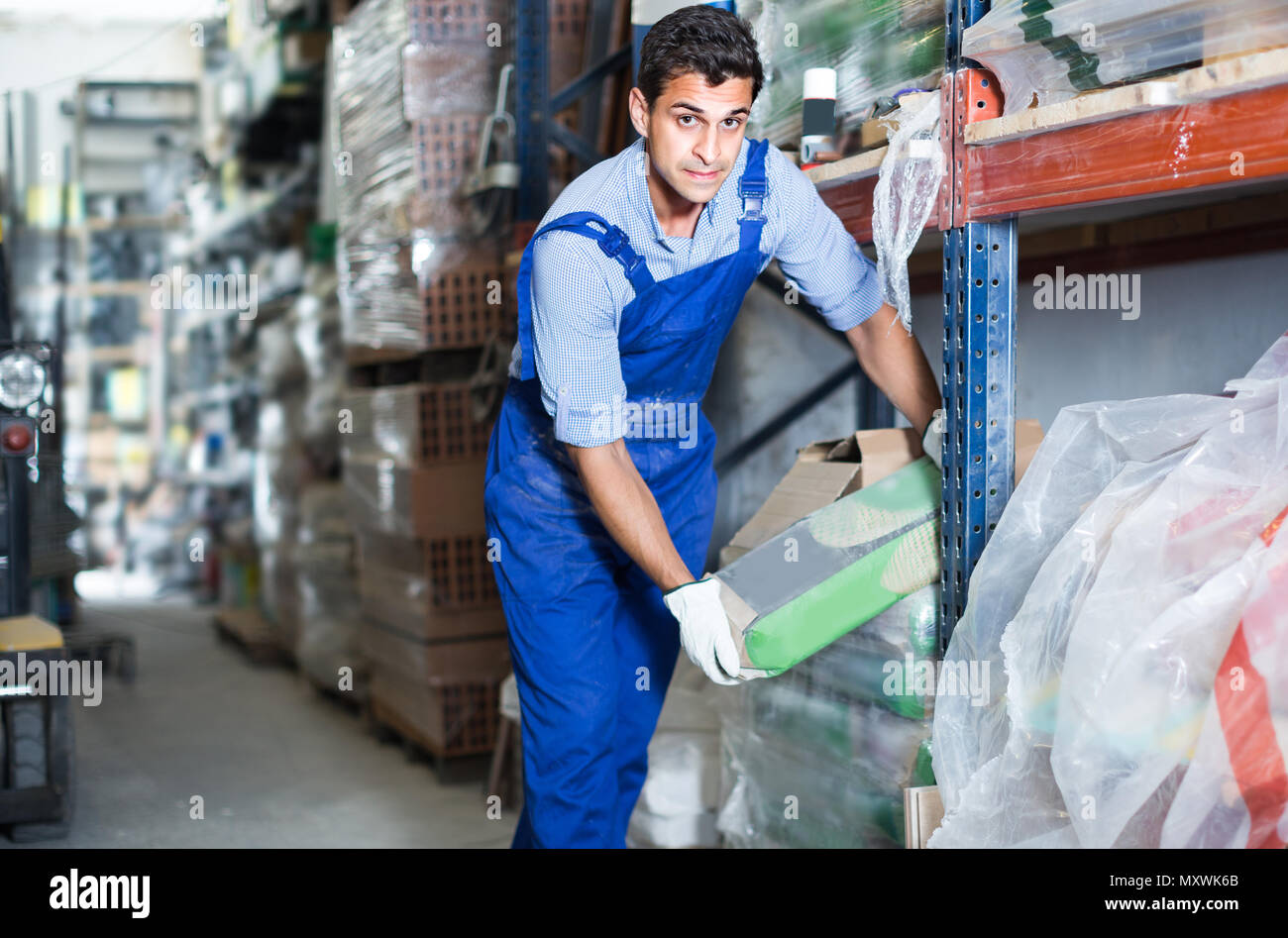 Man in uniform is choosing cement in the building store Stock Photo - Alamy