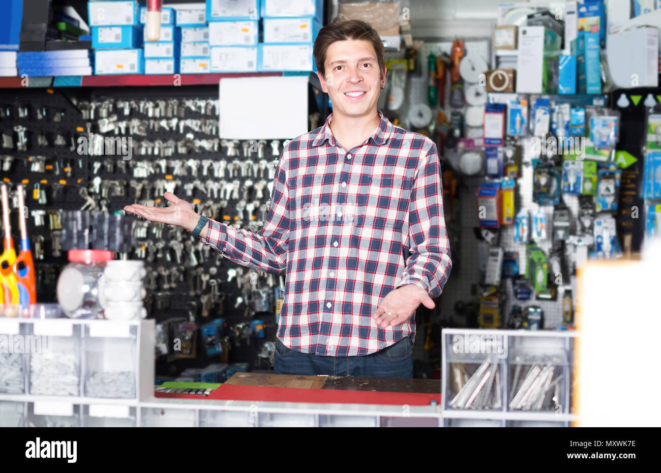 happy spanish worker in hardware store trading goods for water tap in ...