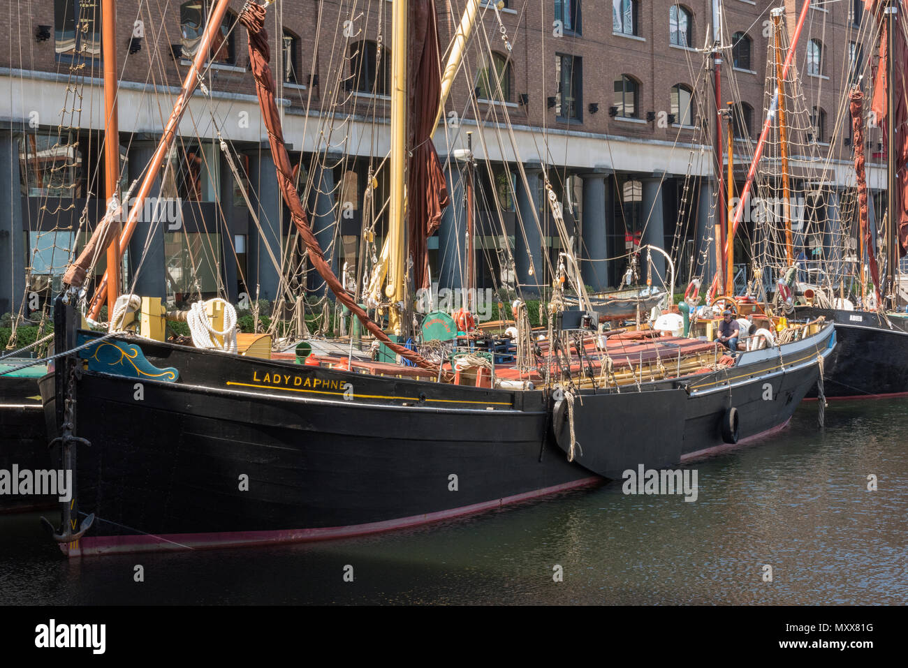 A traditional thames sailing barge or wooden cargo ship alongside in ...