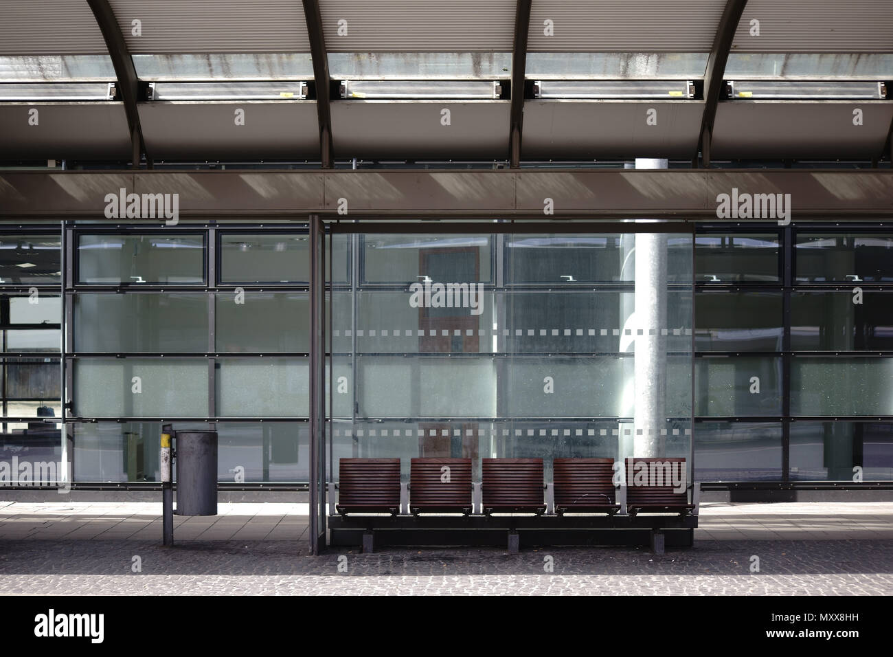 The new built glass shelter of a modern bus stop at a street Stock ...