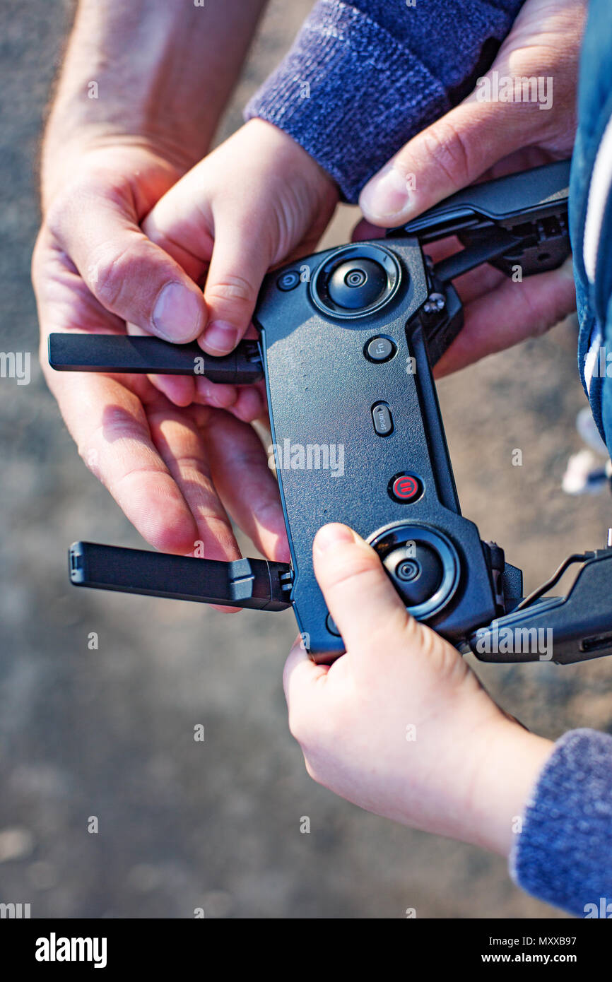 Father and son looking at remote control joystick and piloting ...