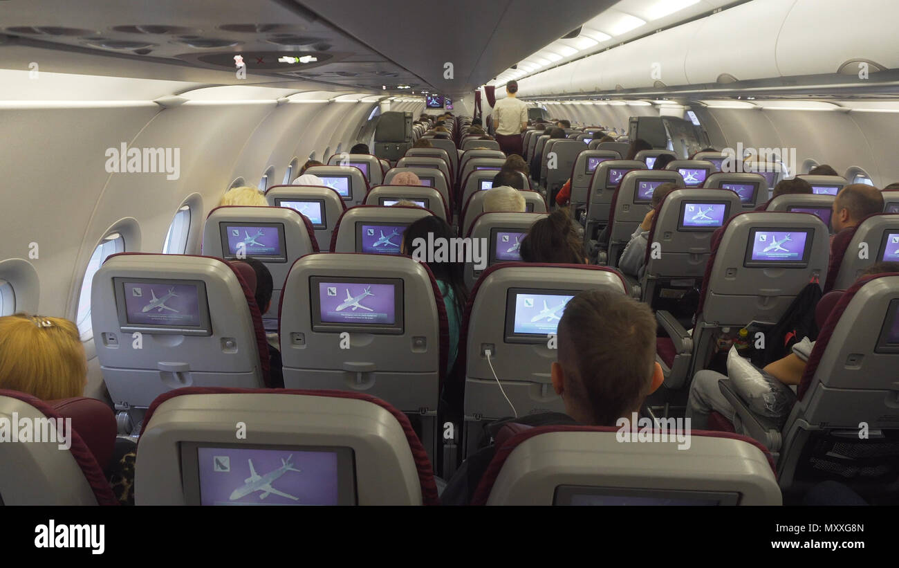 Interior passengers airplane with people on seats. Aircraft cabin with ...