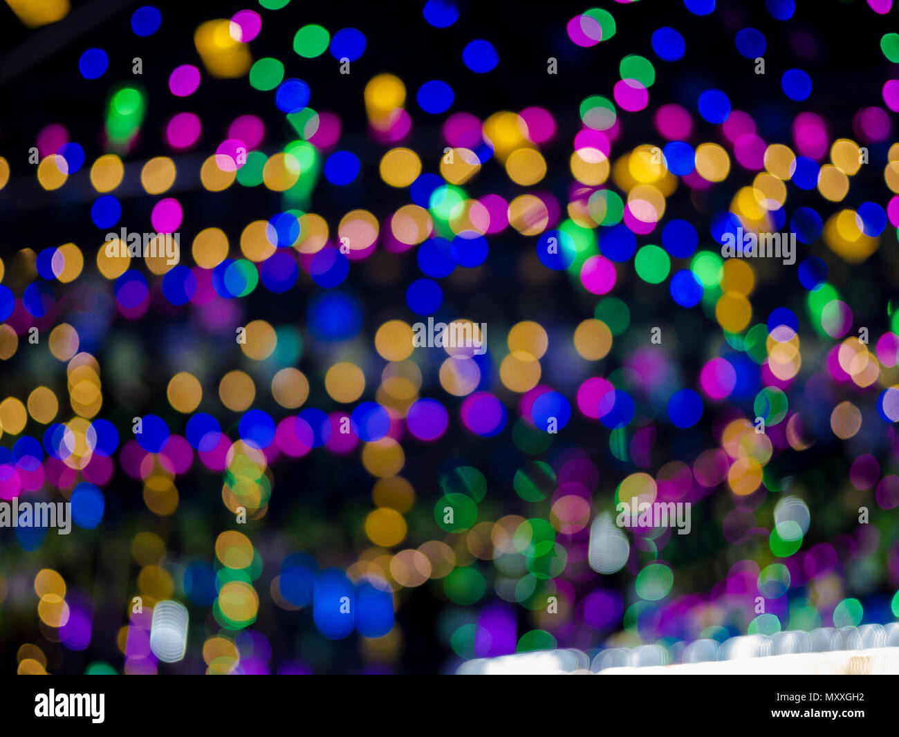 Abstract image of unfocused multicolored lights shining in the night ...