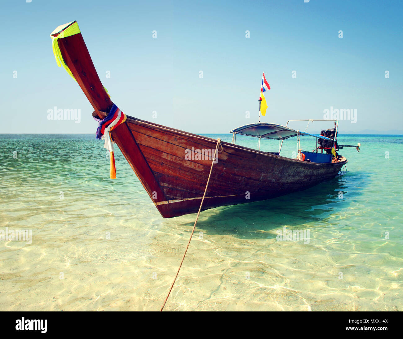 Traditional Thai Longboat floating in the warm clear waters Stock Photo - Alamy