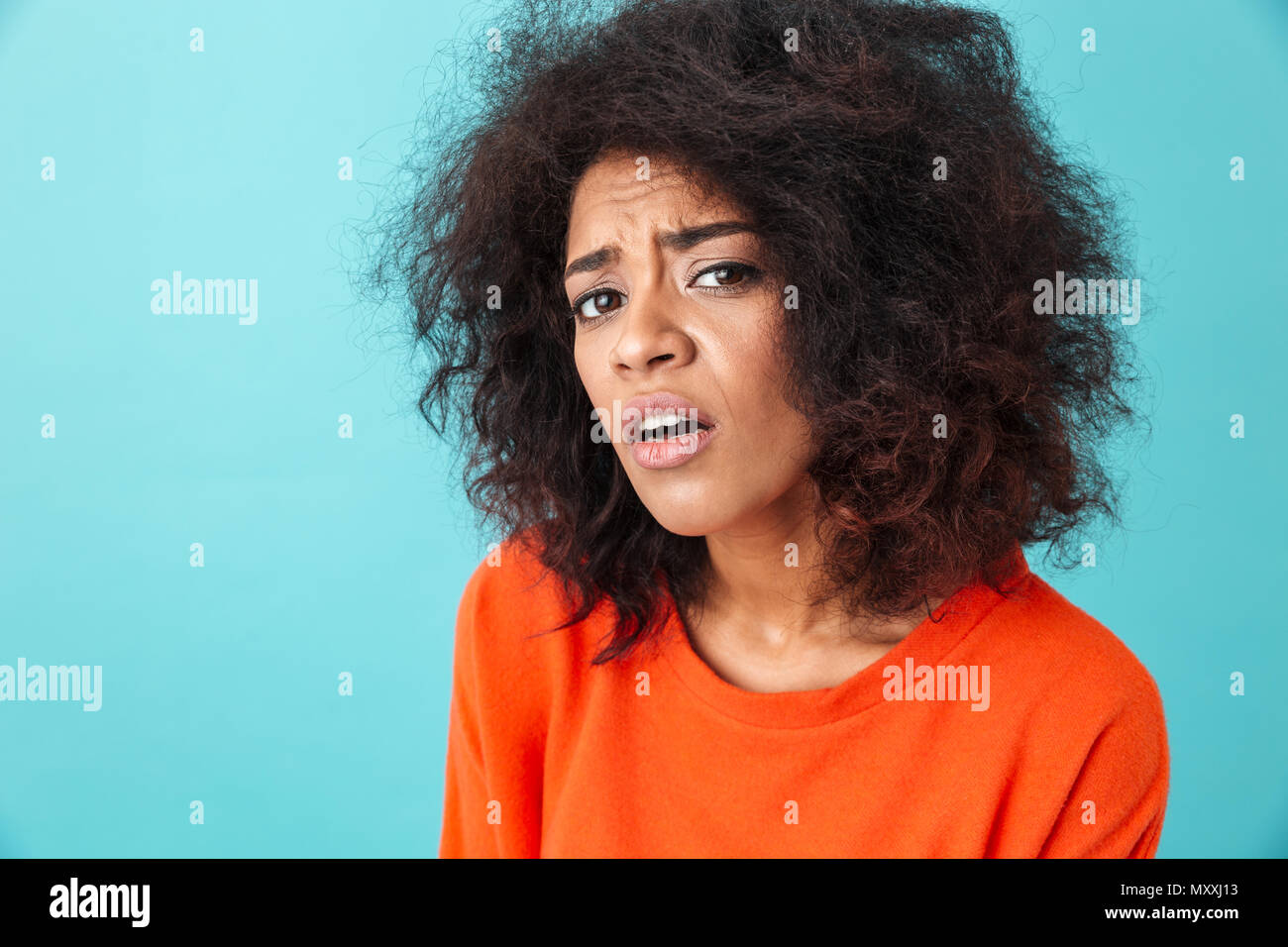 Colorful image closeup of puzzled woman in red shirt looking on camera ...