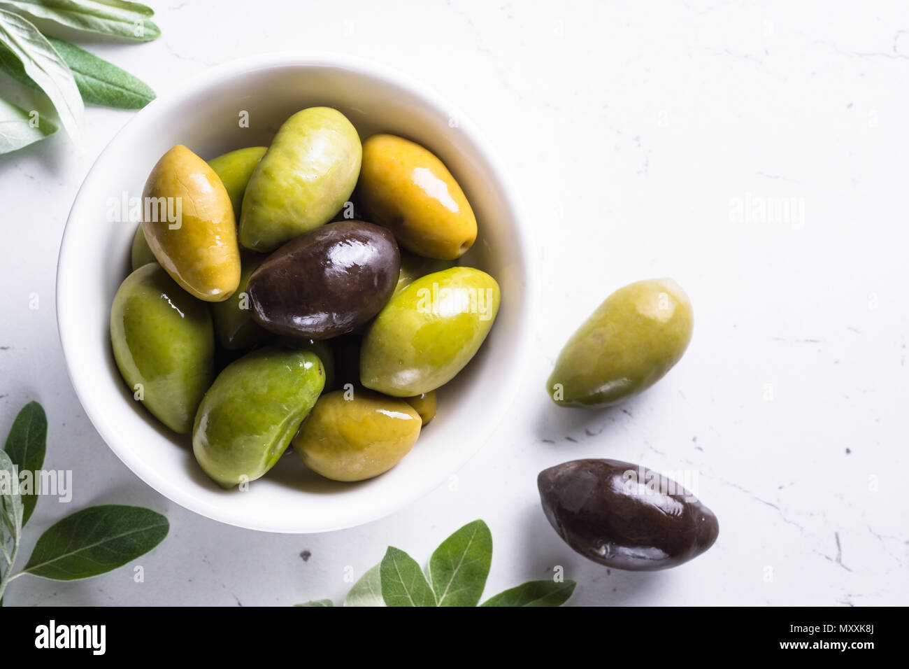 Olives in a bowl on white marble table. Top view with copy space Stock ...