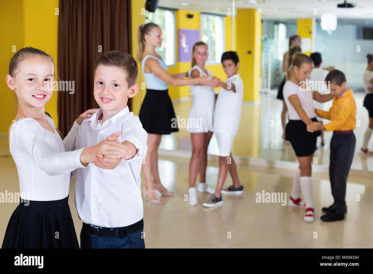 Group of friendly positive children dancing tango in dance studio Stock ...