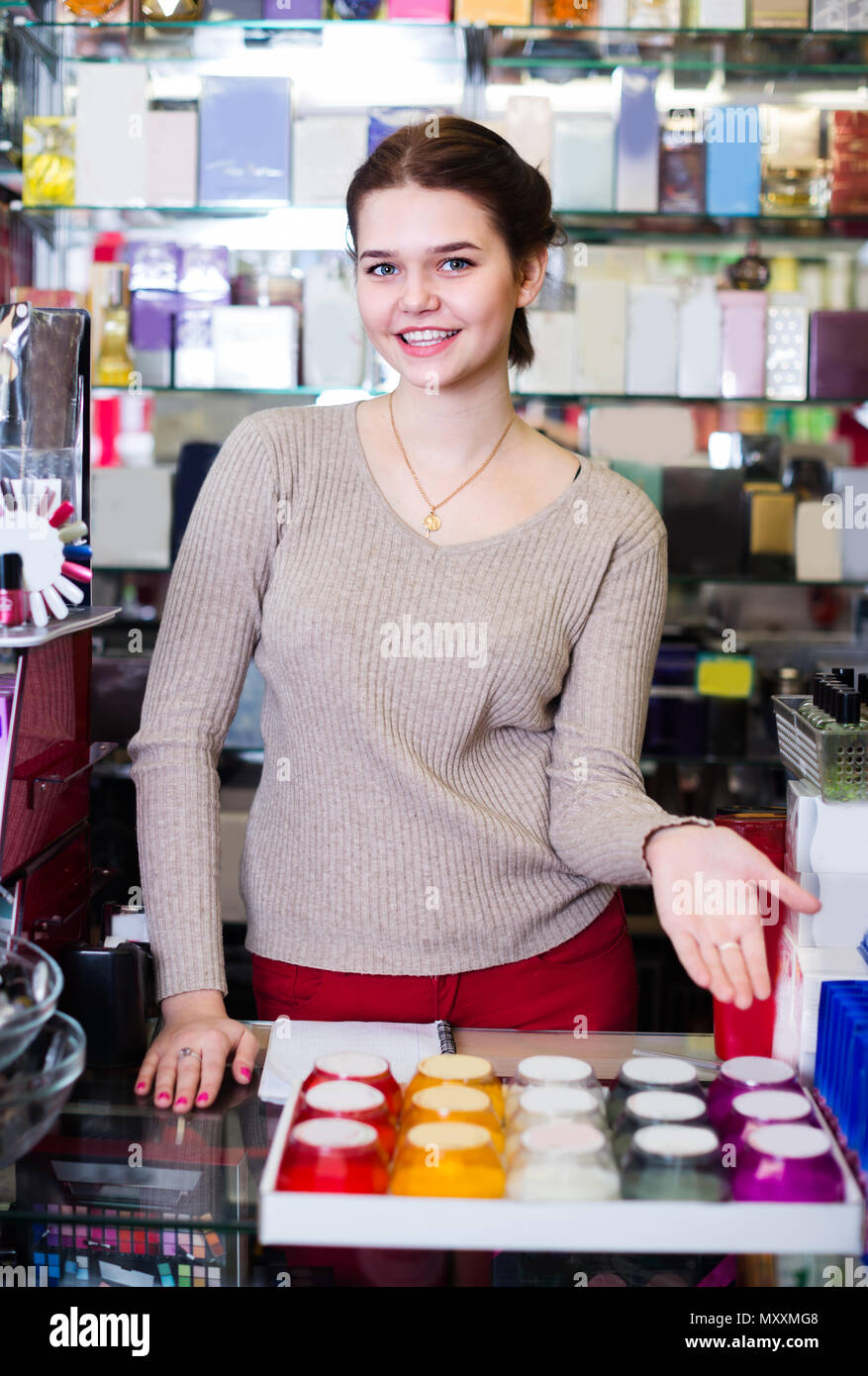 Female shop assistant is displaying assortment in cosmetics shop Stock ...