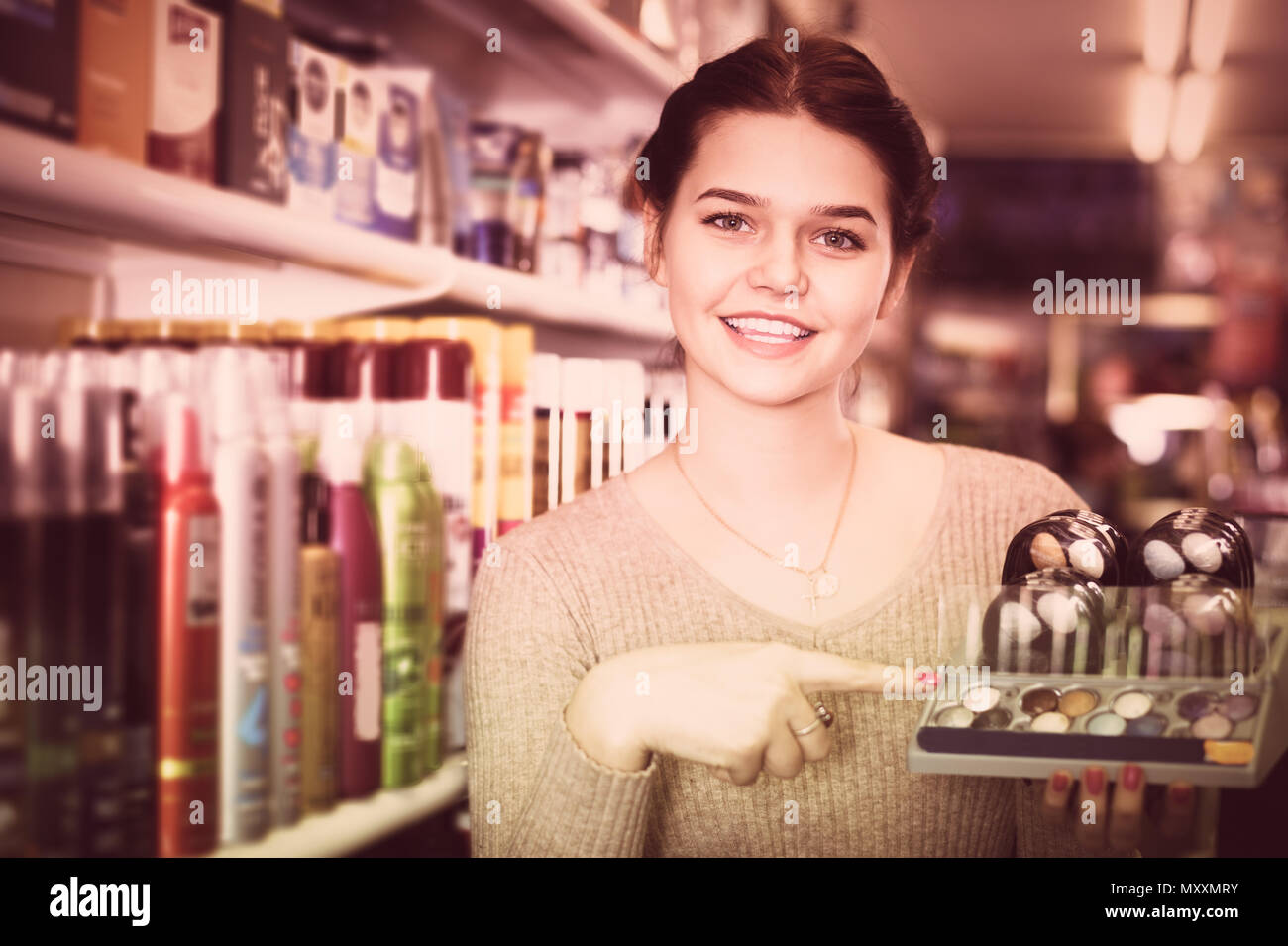 Female seller demonstrating assortment of cosmetics shop Stock Photo ...