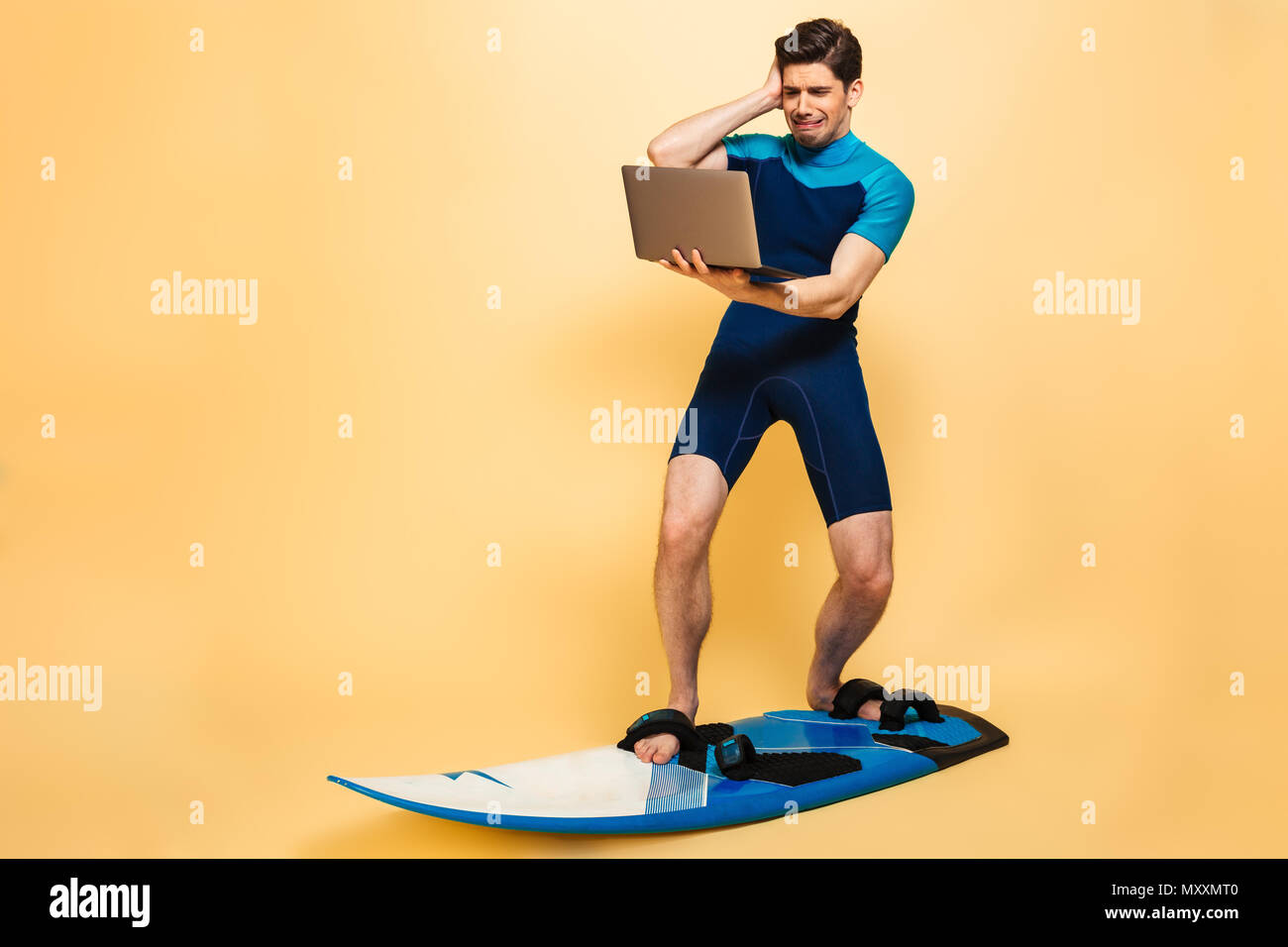 Full length portrait of an upset young man dressed in swimsuit holding ...