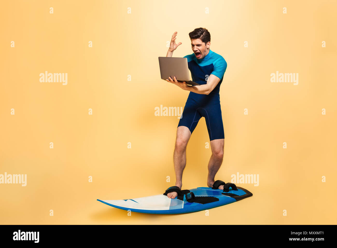 Full length portrait of an angry young man dressed in swimsuit holding ...