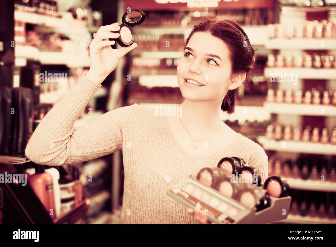 Happy seller demonstrating assortment of cosmetics shop Stock Photo - Alamy