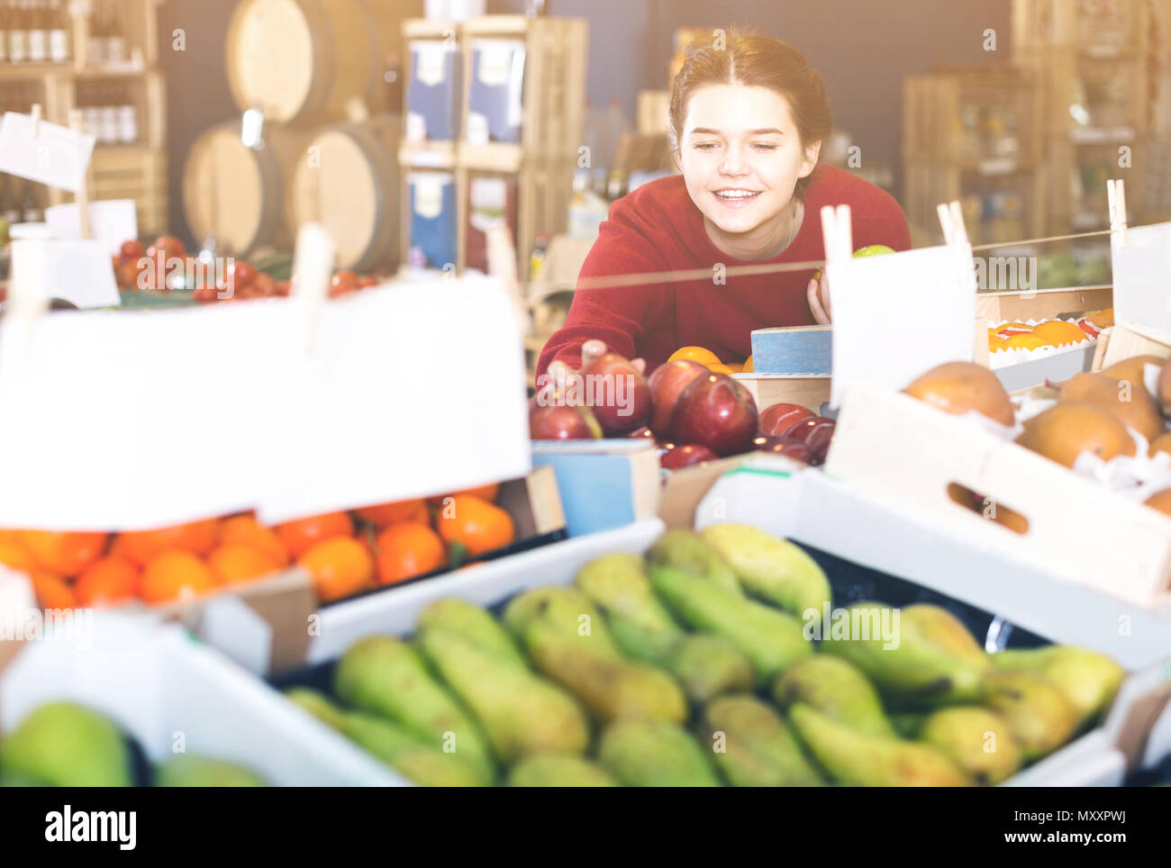 portrait of positive young customer selecting apple in grocery Stock ...