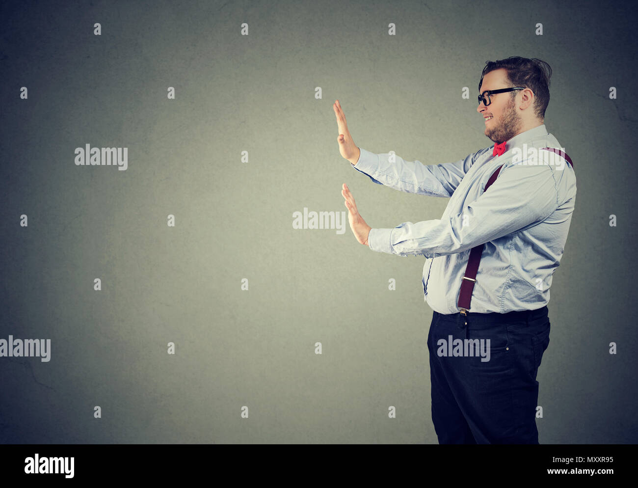 Side view of a business man in formal outfit holding hands up in front ...