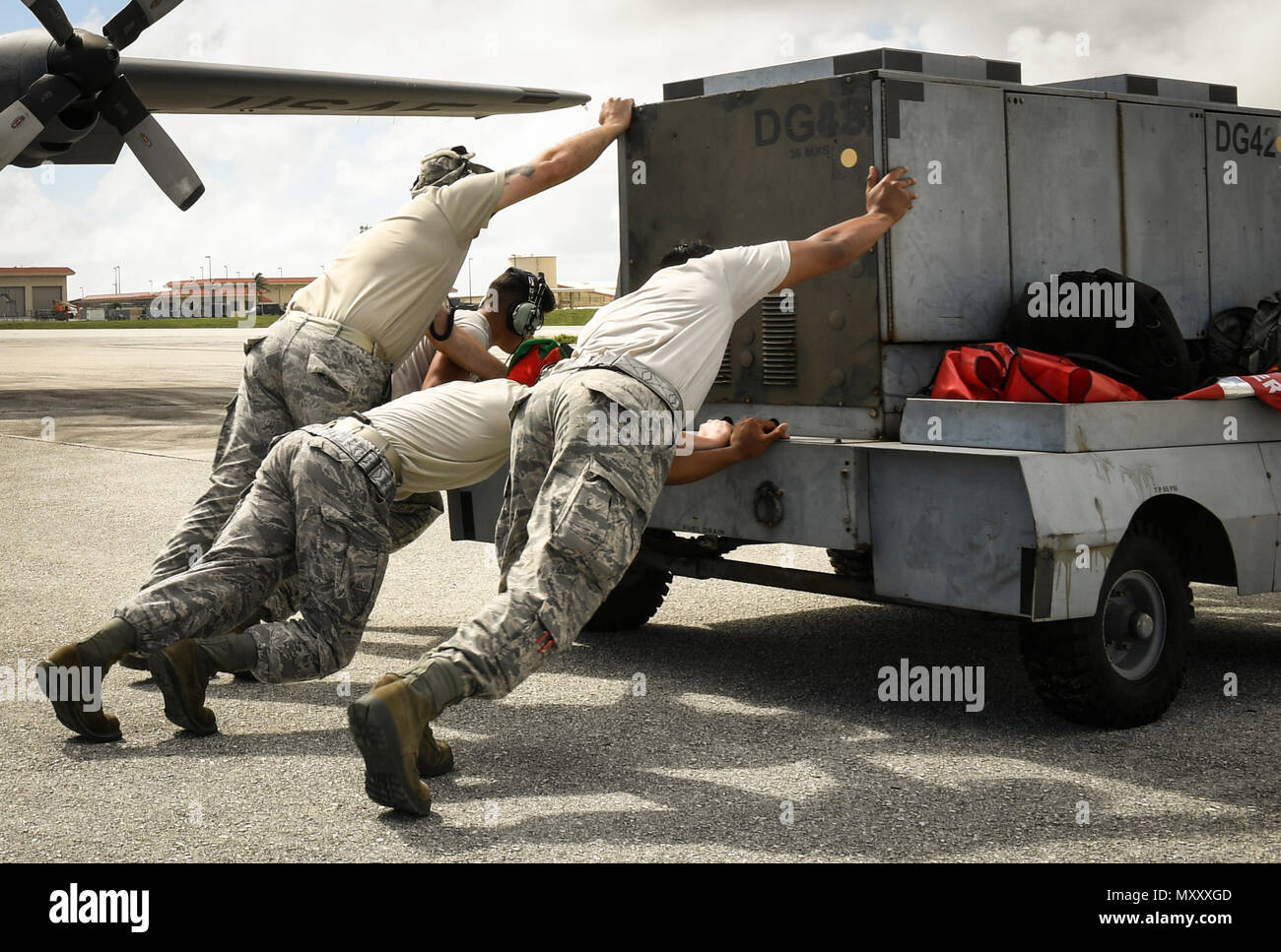 Members of the 374th Maintenance Group move a power cart in preparation ...
