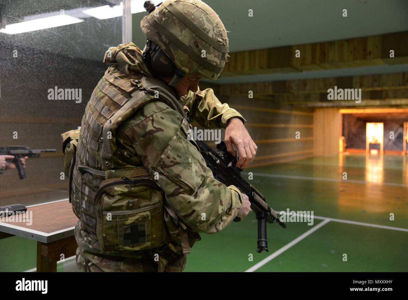 Member of the British Armed Forces, assigned to local units, loads a ...