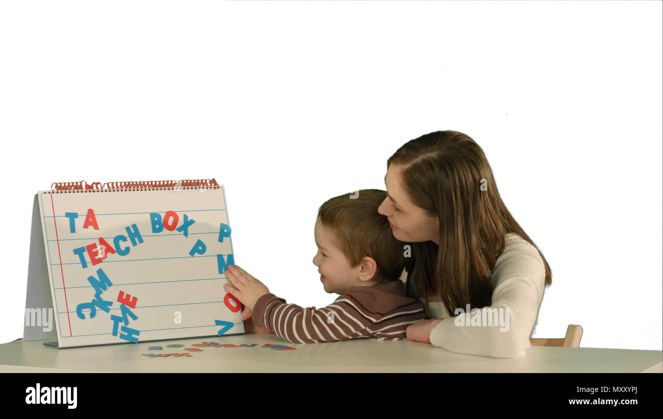 Mother and son make word Mama on the desk on white background isolated ...