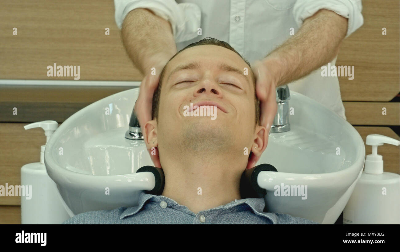 Young man lying with his eyes closed in beauty saloon. Handsome man ...