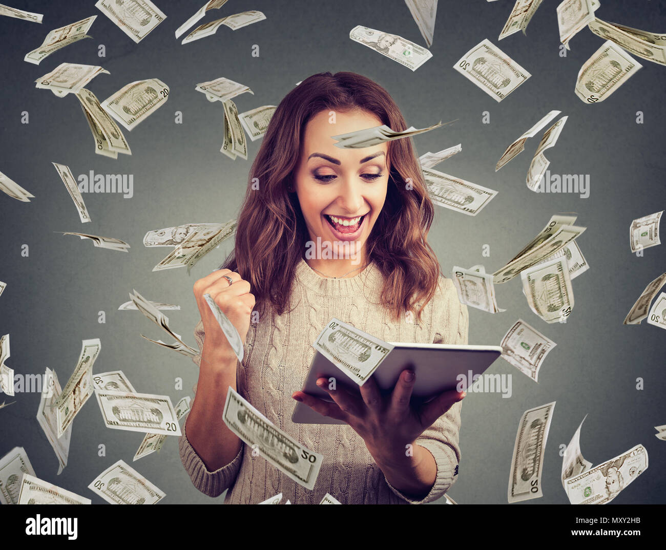 Cheerful woman with table happy with lottery win and holding fist up in ...