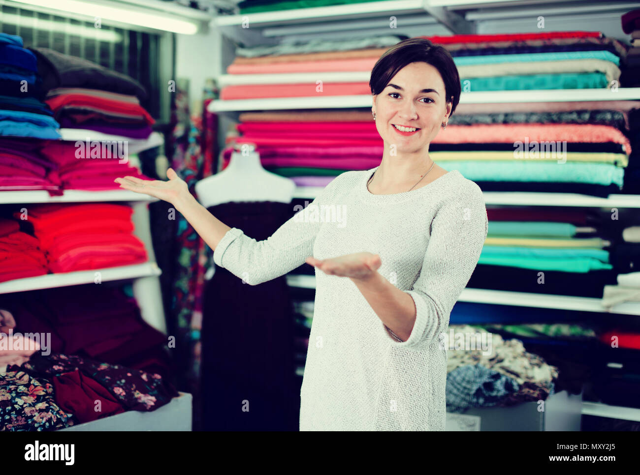Female shop assistant demonstrating assortment at drapery shop Stock ...