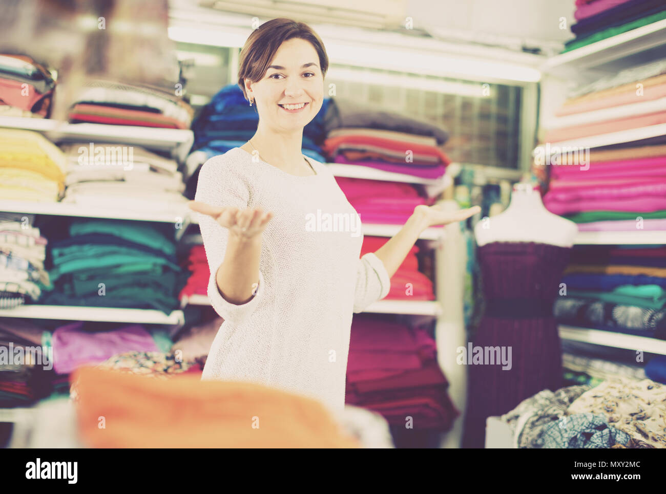 Female shop assistant demonstrating assortment at drapery shop Stock ...