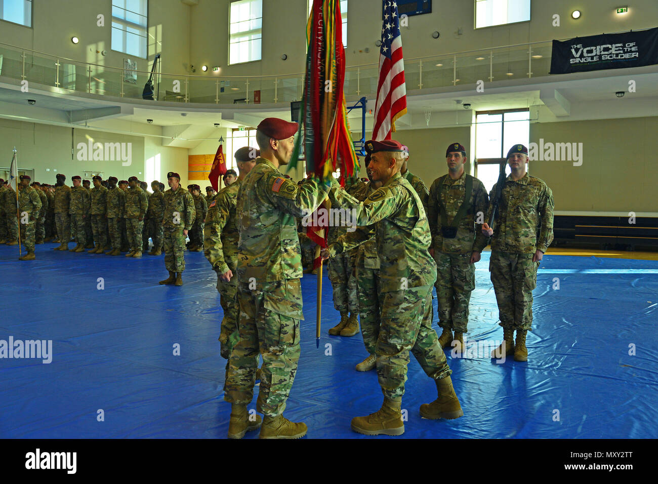 U.S. Army Command Sgt. Maj. Todd M. Burke, right, passes the flag to Lt ...