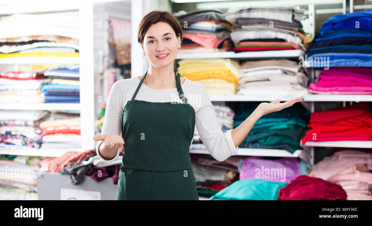 Female shop assistant demonstrating assortment at drapery shop Stock ...