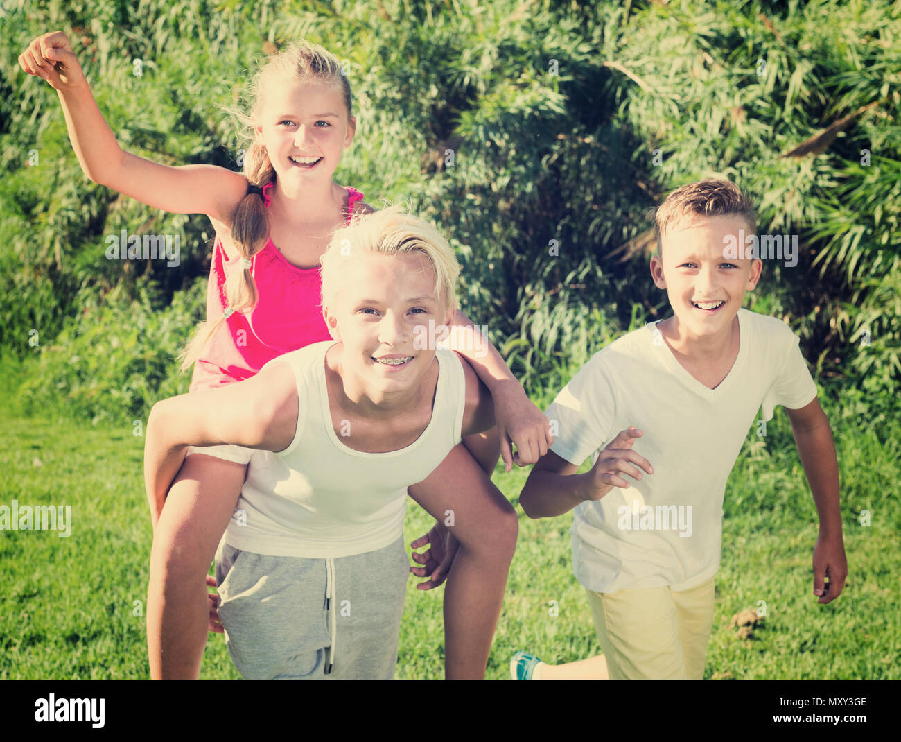 Group of laughing kids running happily together on grass Stock Photo ...