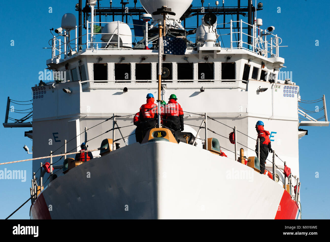 The crew of the Coast Guard Cutter Spencer congregates on the bow of ...
