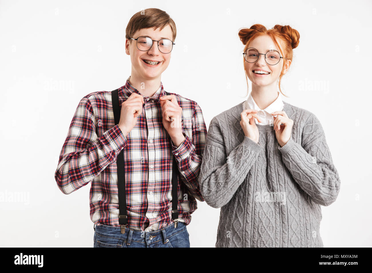 Happy couple of school nerds looking at camera isolated over white ...
