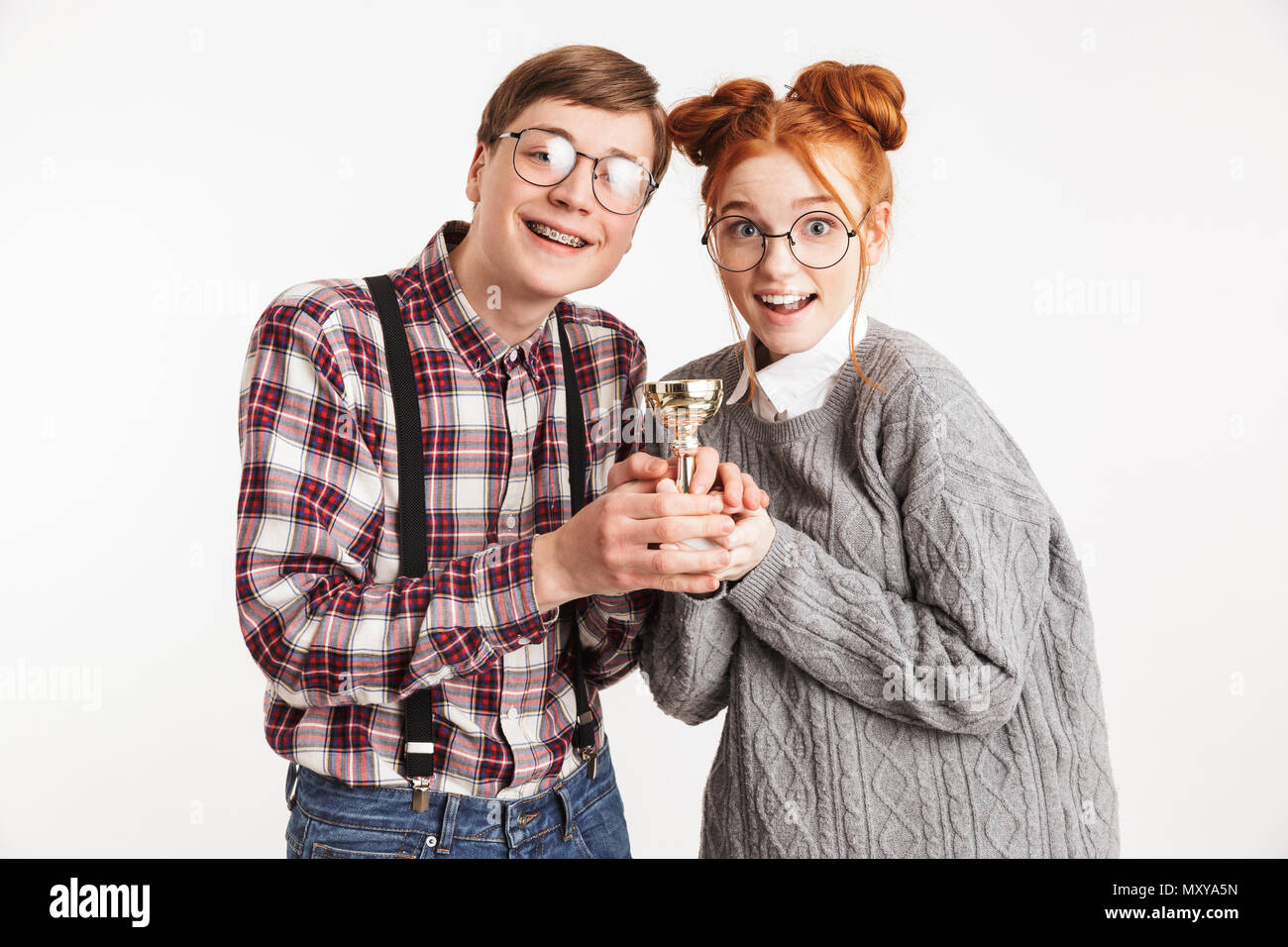 Smiling couple of school nerds holding winners trophy isolated over ...